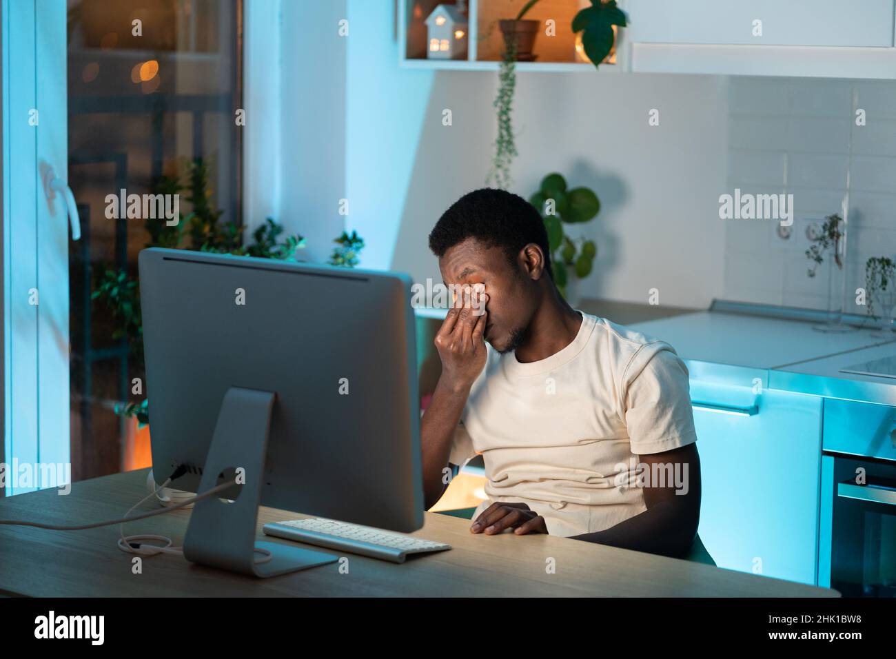 Overworked african man freelancer feeling eye strain and fatigue during ...