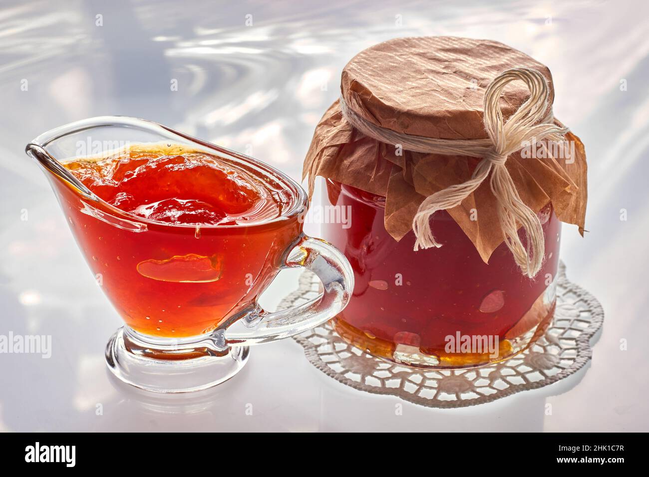 Fruit jam in a glass bowl and jar on a white sunny background Stock ...