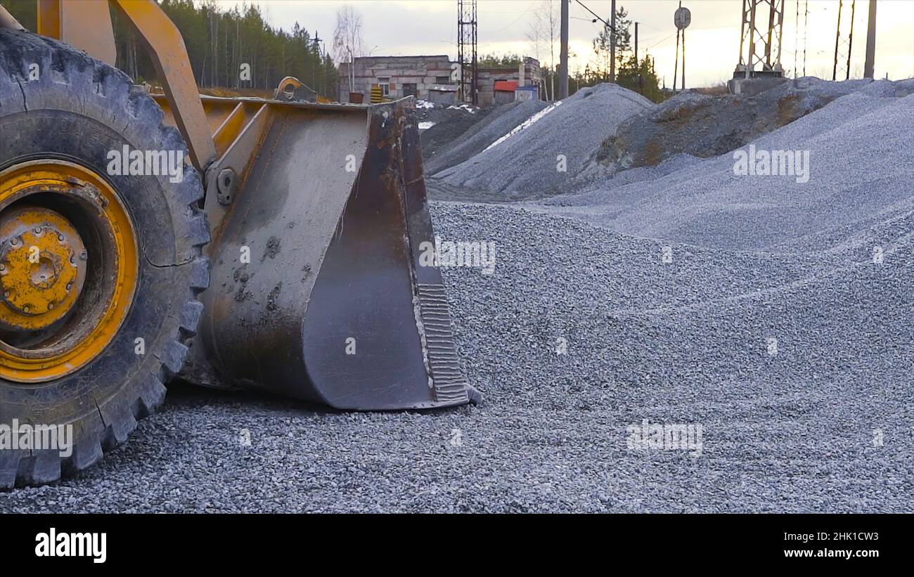 Tractor moves rubble to truck. Stock footage. Excavator-loader rakes ...