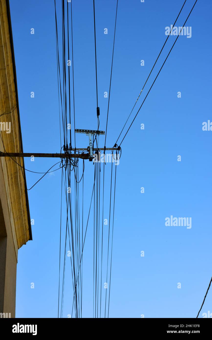 Power lines on a house facade and blue sky Stock Photo - Alamy