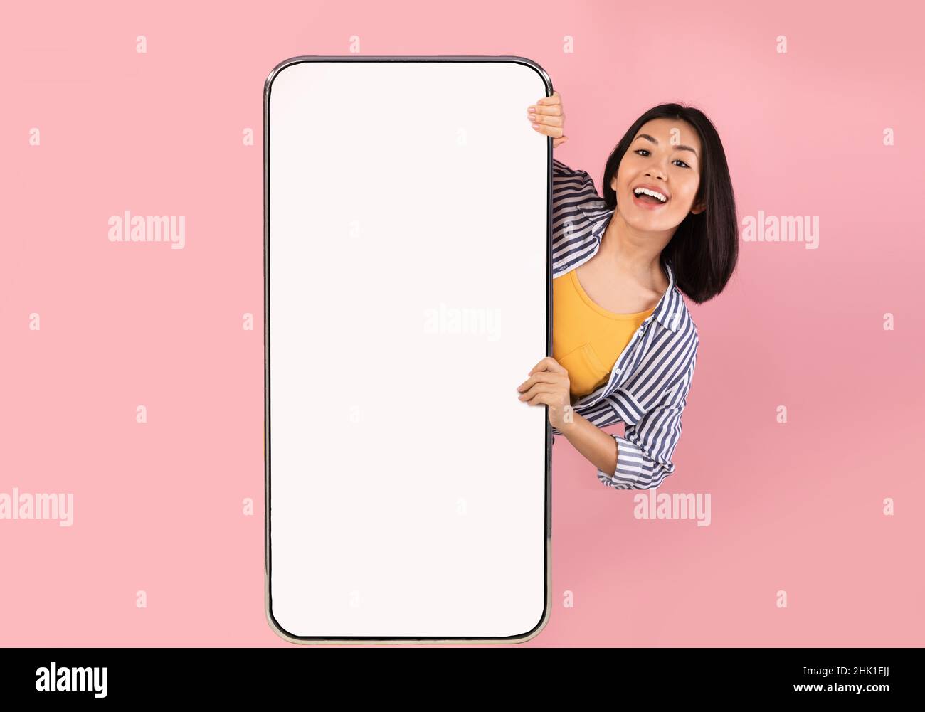 Cheerful asian lady showing big white empty smartphone screen Stock ...