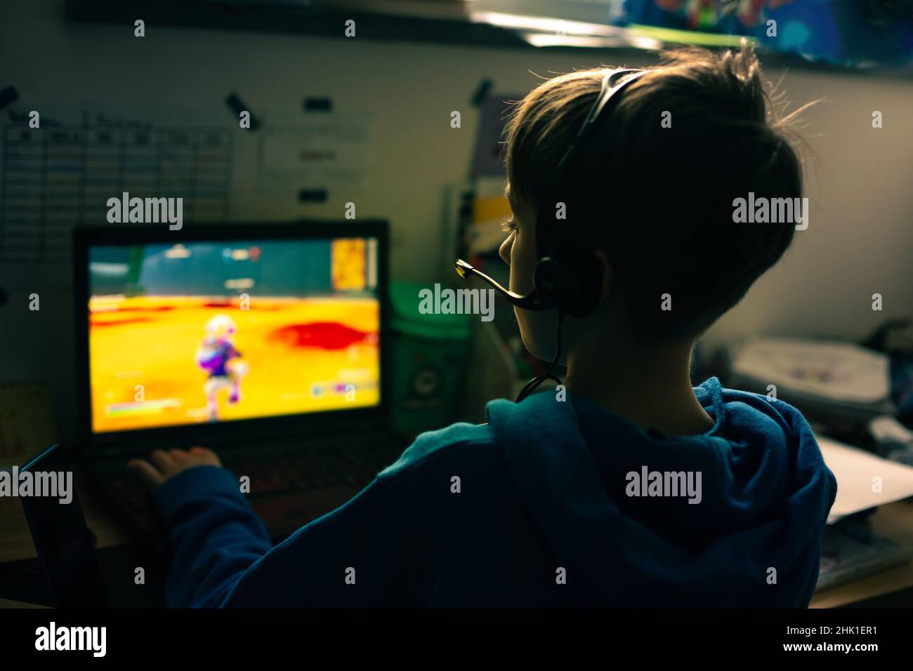 Child gaming on laptop playing addictive online video game at home in ...