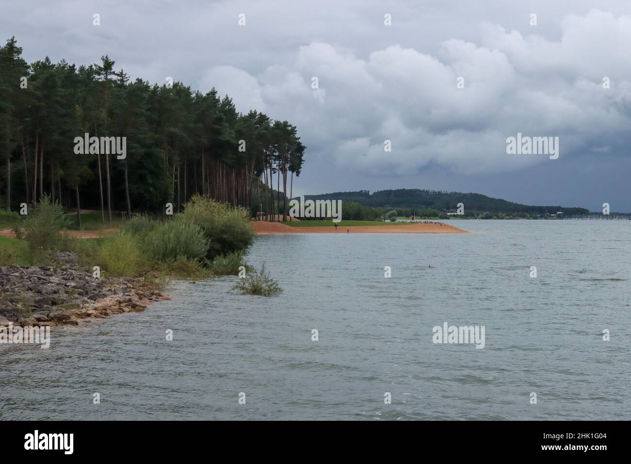 Shot of forest and beach with sea and cloudy sky in Brombachsee ...