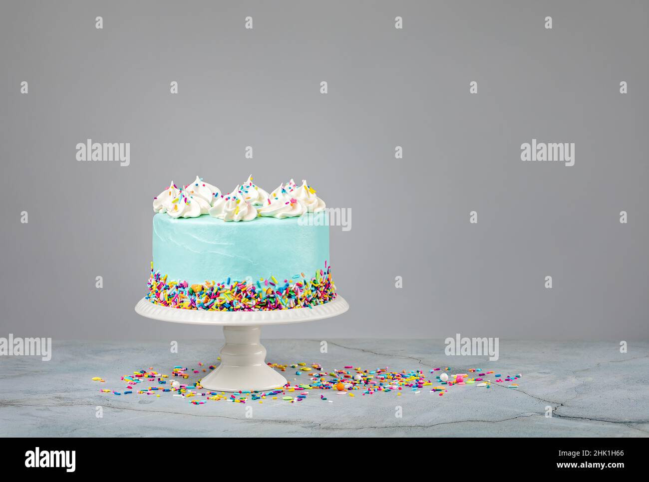 Blue Birthday Cake with colorful sprinkles over a light grey background ...