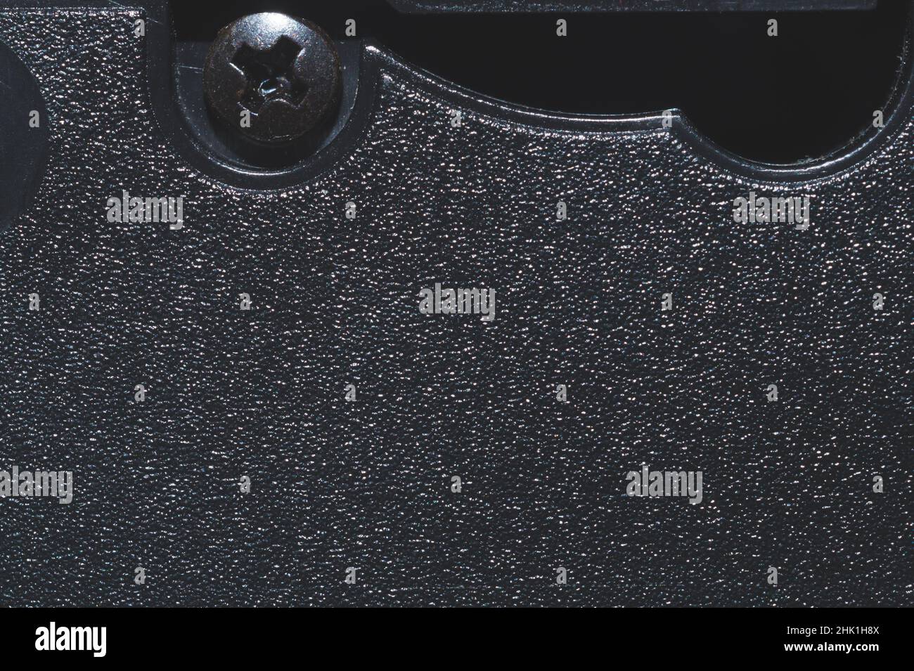 Black plastic surface with screw. detail of plastic cassette close up ...