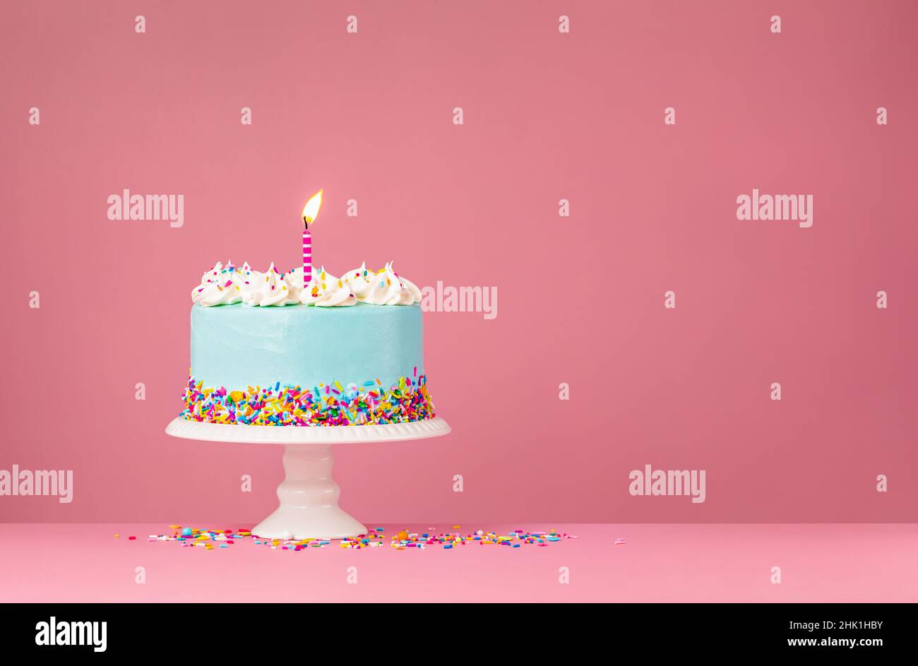 Blue Birthday Cake With Colorful Sprinkles And Lit Birthday Candle Over