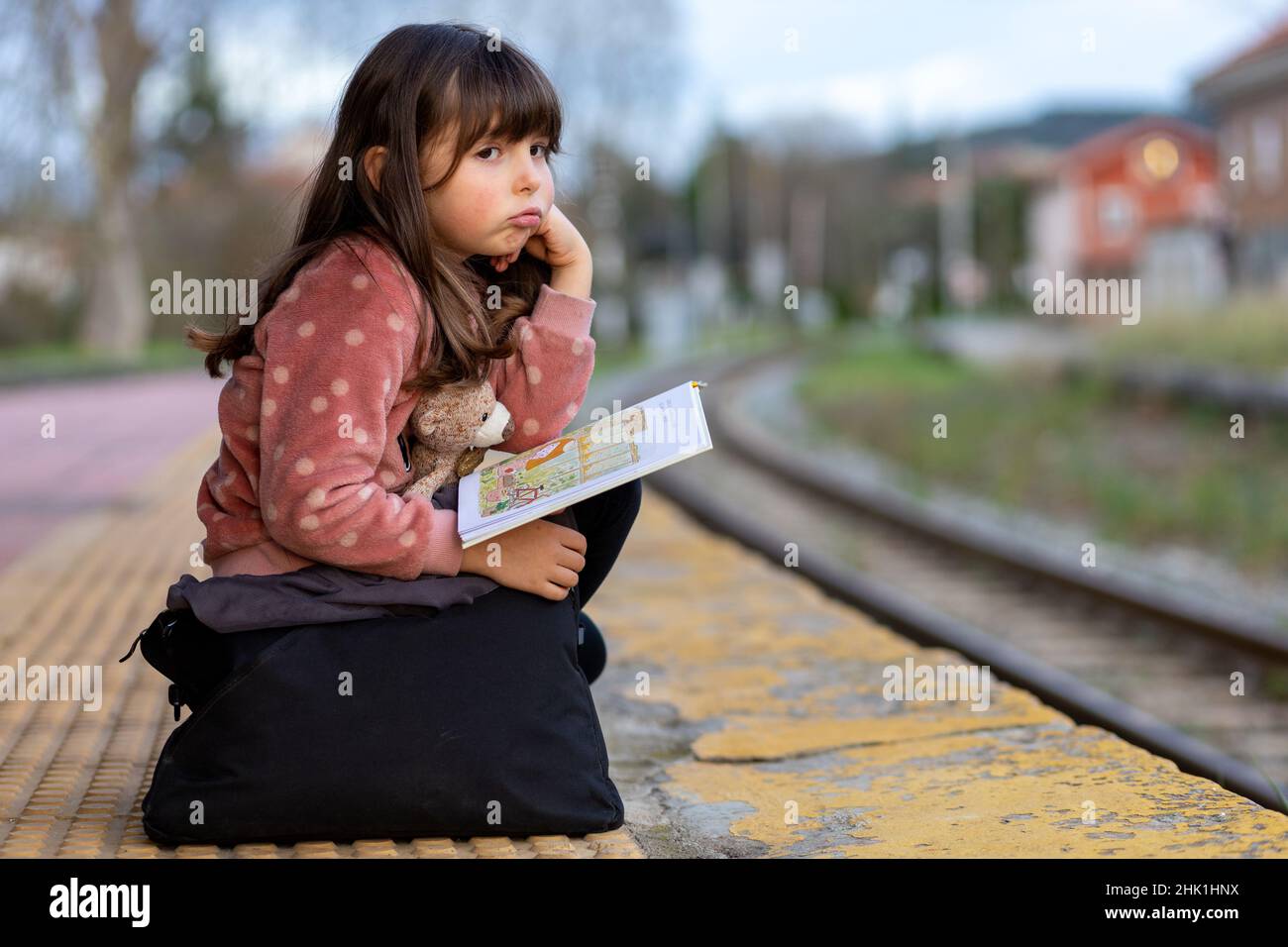 Bored girl waits for the arrival of the train Stock Photo - Alamy