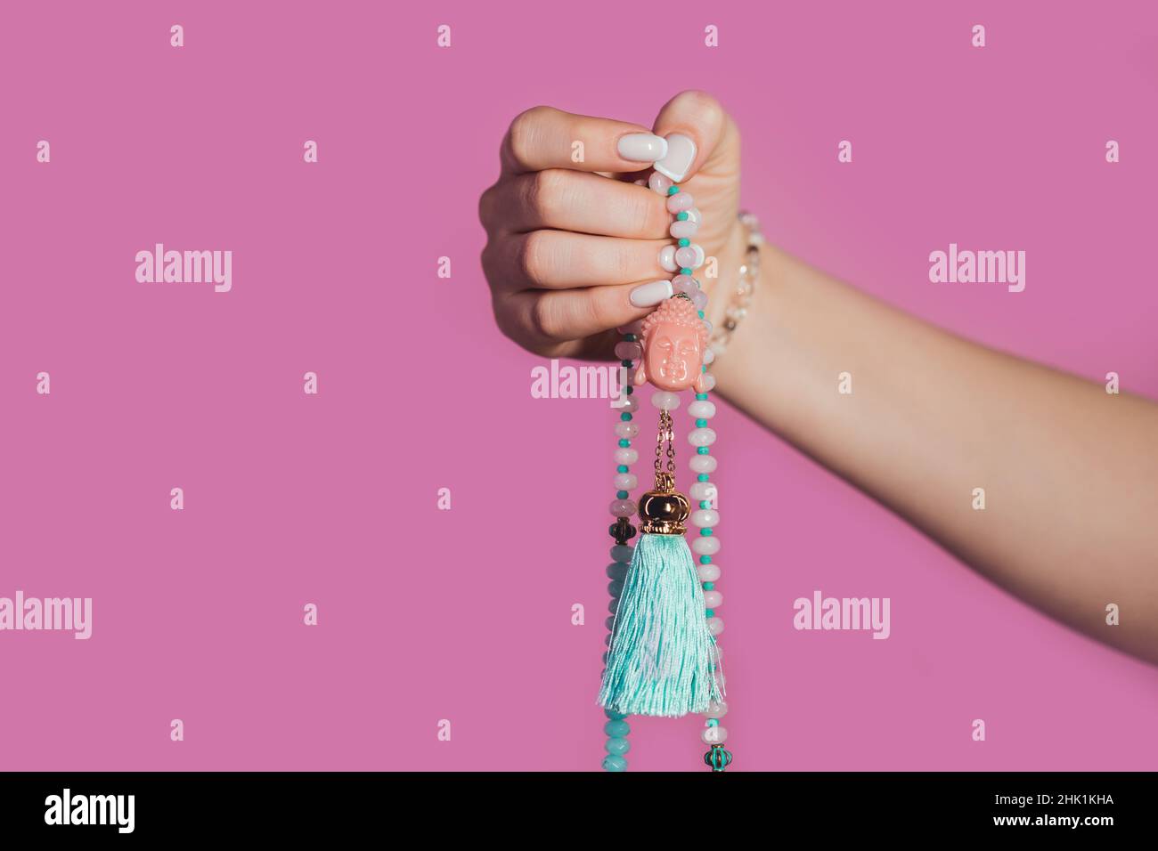 Woman lit hand counts mala beads strands of gemstones used for keeping ...