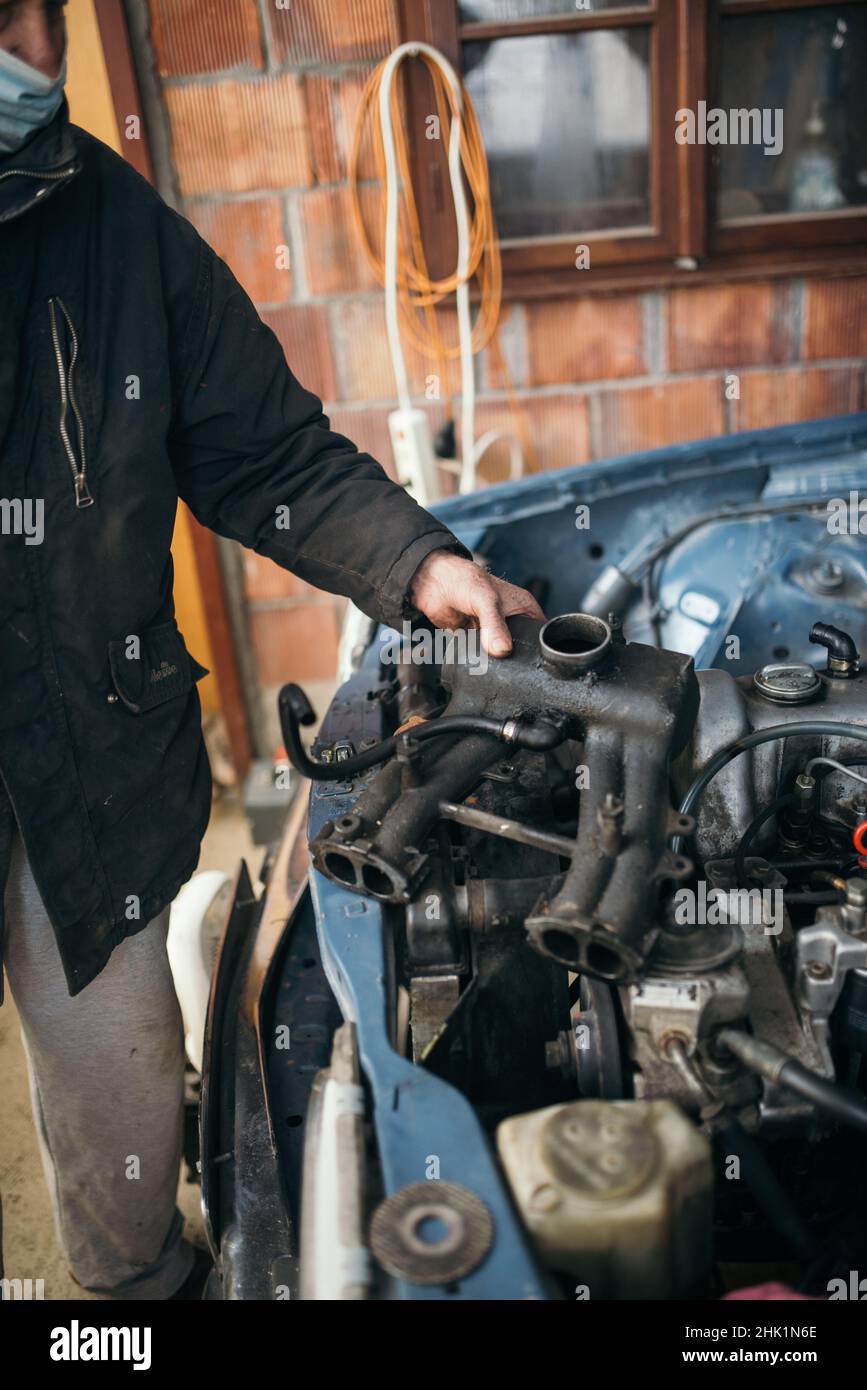 An old man holding engine part closeup Stock Photo - Alamy