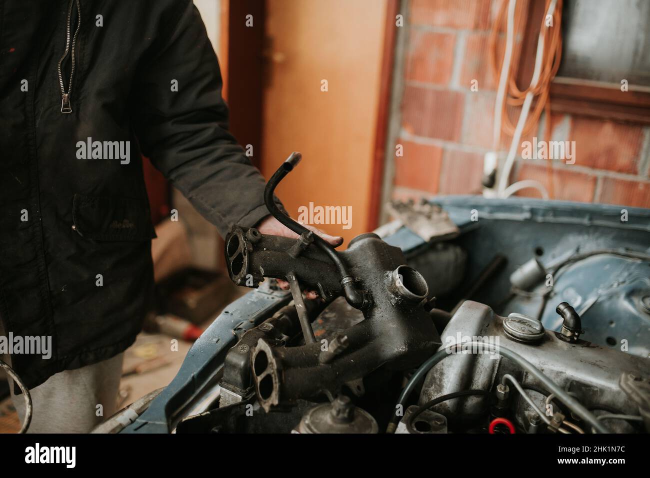 Old man holding an old part of a car closeup Stock Photo - Alamy
