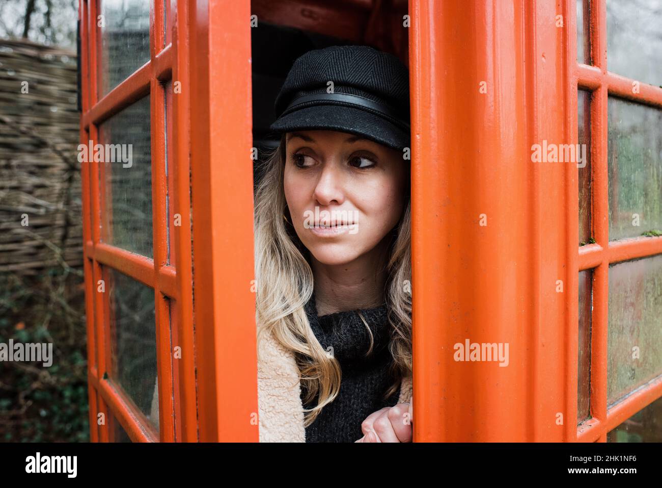 woman looking out of a traditional English Phone box Stock Photo - Alamy
