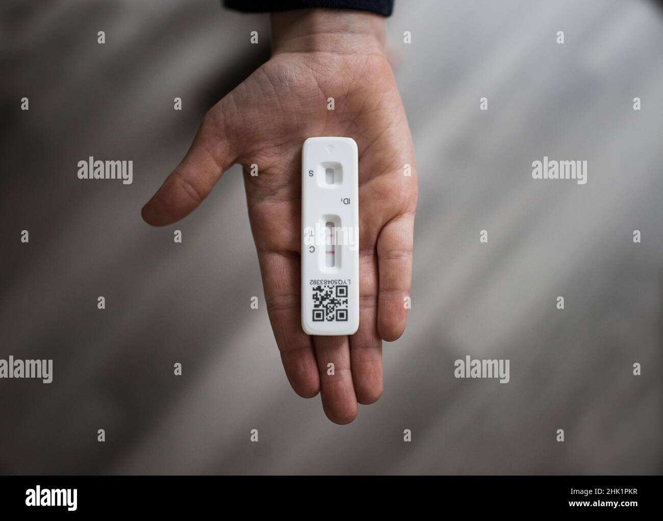 child's hand holding positive lateral flow COVID test Stock Photo - Alamy