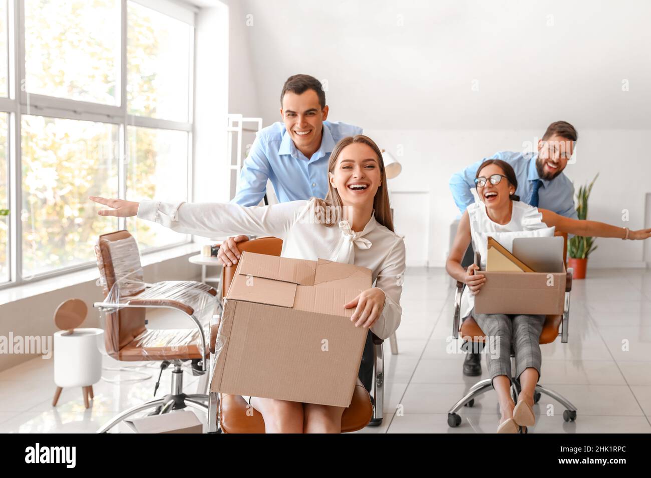 Business people having fun while packing things in office on moving day ...