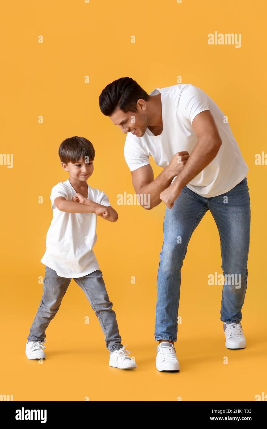 Happy dancing man and his son on color background Stock Photo - Alamy