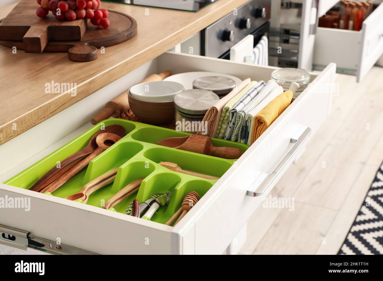 Opened drawers with kitchen utensils in room Stock Photo - Alamy