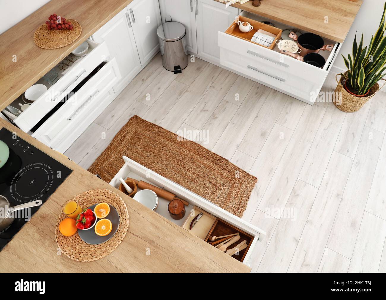 Interior of stylish kitchen with modern counters and opened drawers ...