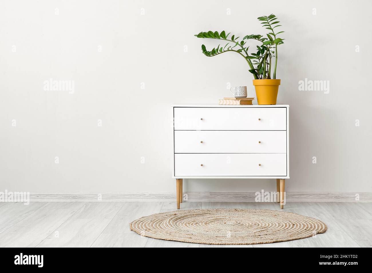 Interior of room with chest of drawers and stylish wicker carpet Stock ...