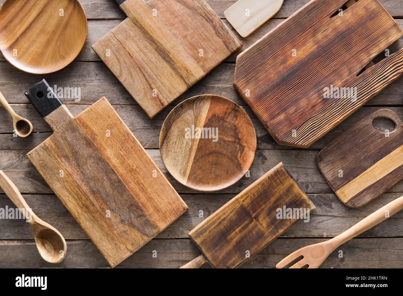 Different cutting boards and plates on wooden background Stock Photo ...