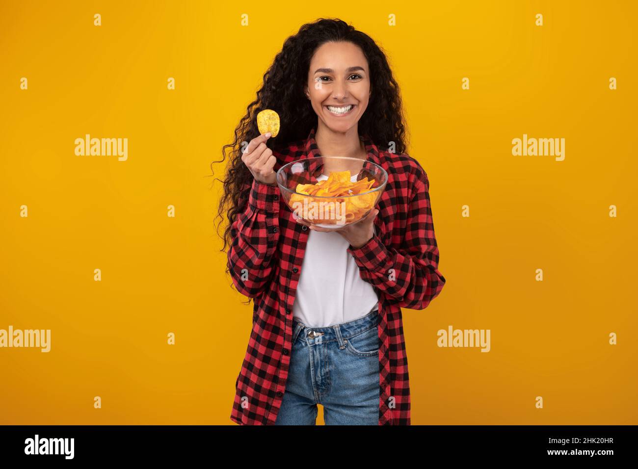 Excited Latin Lady Eating Delicious Potato Crisps Stock Photo - Alamy