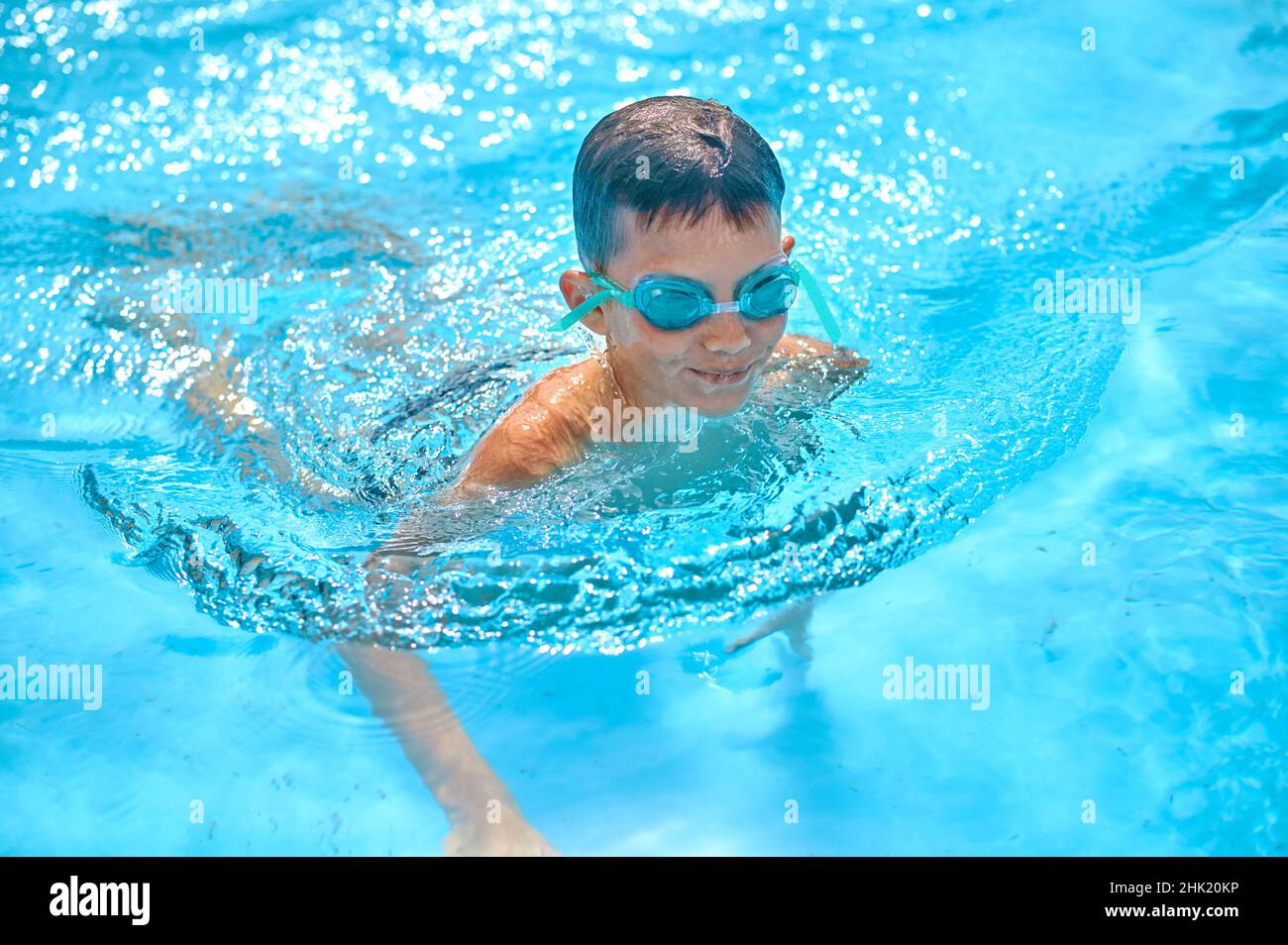 Boy in goggles swimming in pool Stock Photo - Alamy