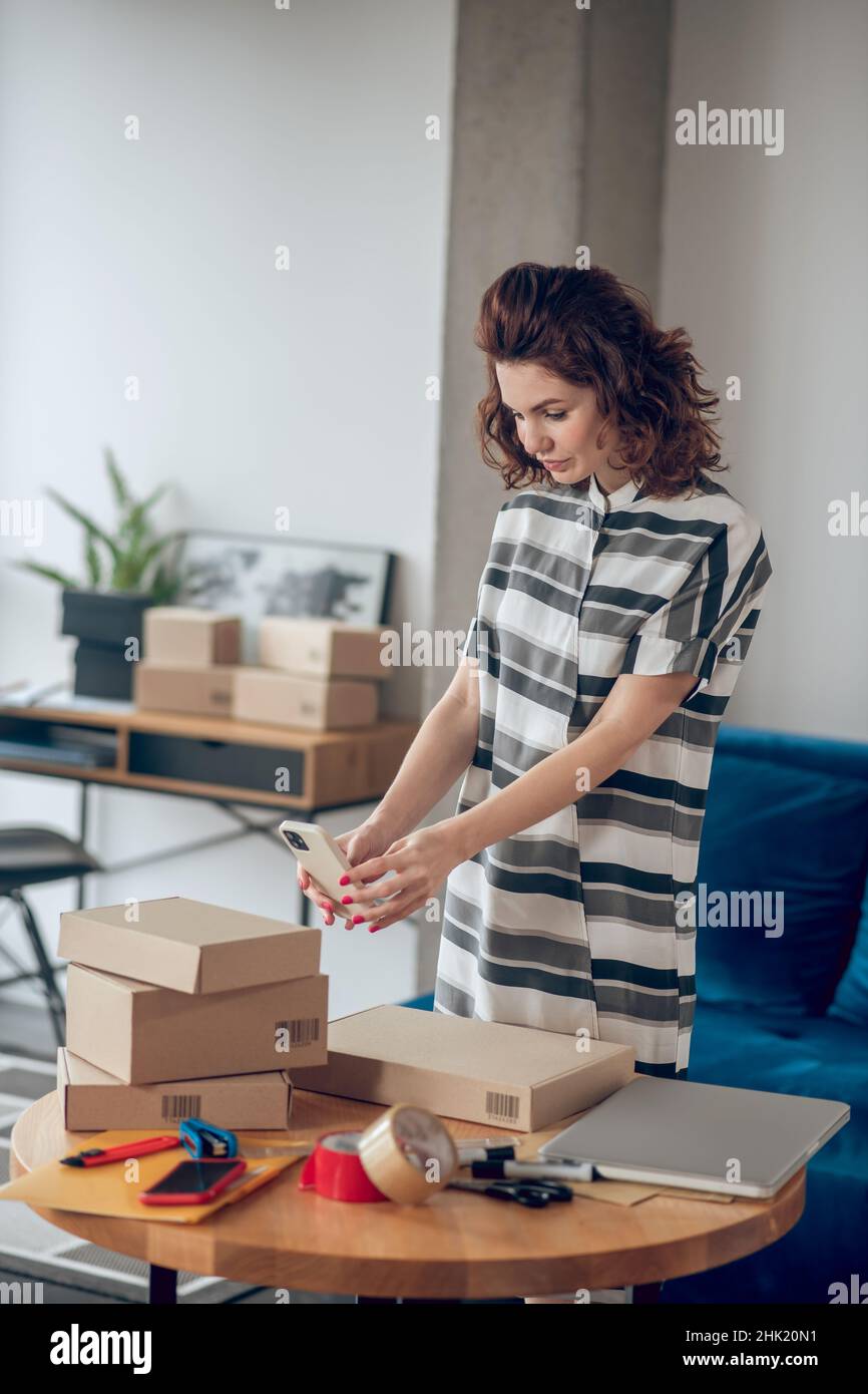 Employee aiming her smartphone camera at the cardboard box Stock Photo ...