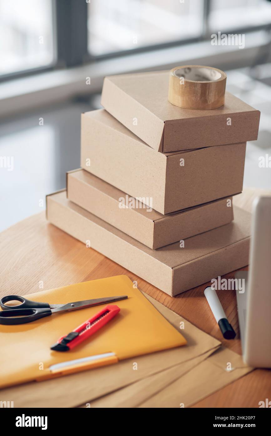 Packages stacked on a round wooden office desk Stock Photo - Alamy