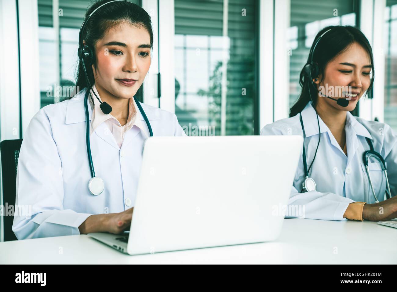 Doctor wearing headset talking actively on video call in hospital or ...
