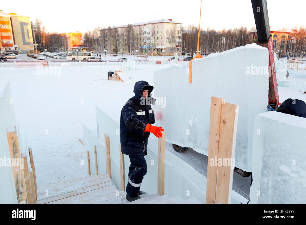 Fitter in a blue hooded jacket at an ice slab installation Stock Photo ...