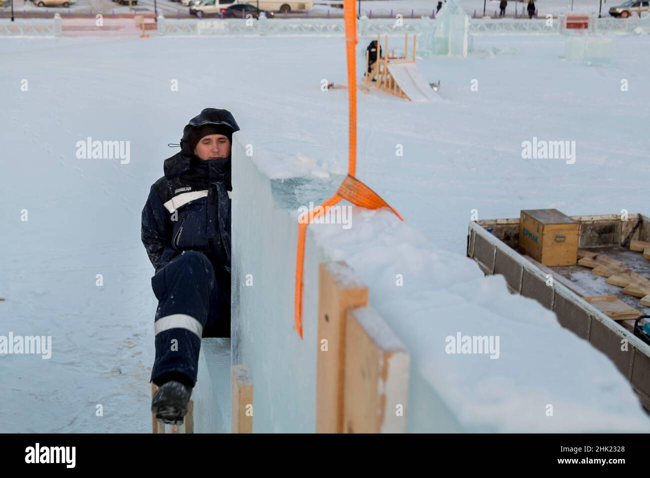 Fitter in a blue hooded jacket at an ice slab installation Stock Photo ...