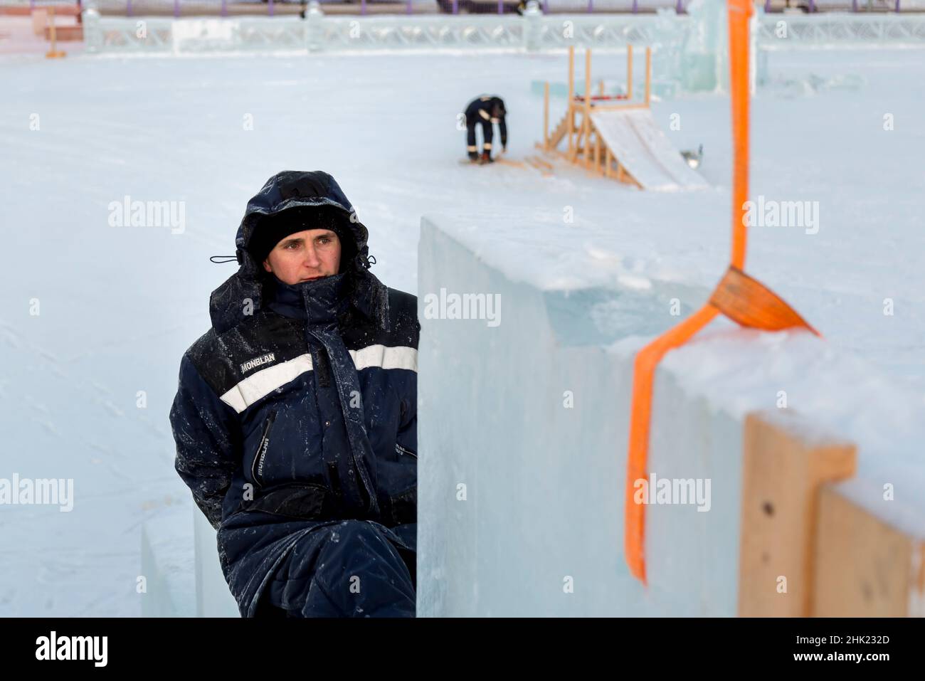 Fitter in a blue hooded jacket at an ice slab installation Stock Photo ...