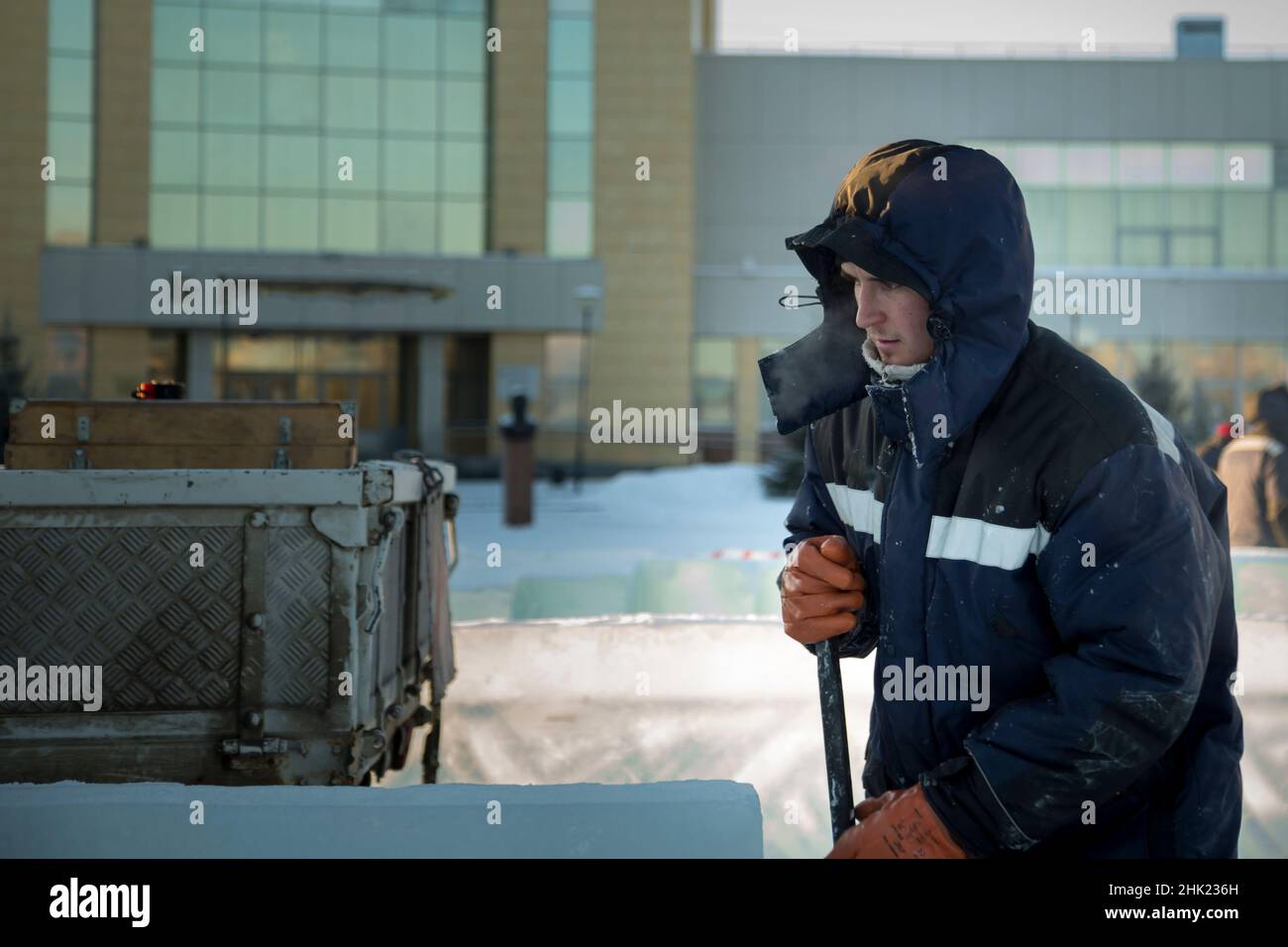 Worker with scrap metal in his hands loading ice blocks Stock Photo - Alamy