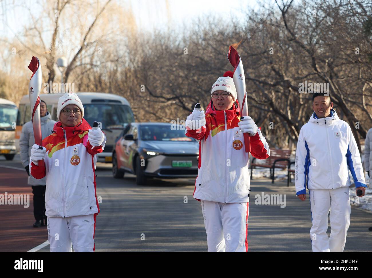 Beijing, China. 2nd Feb, 2022. Torch bearers Li Weihao (C) and Zhang Wenmin (L) attend the ...