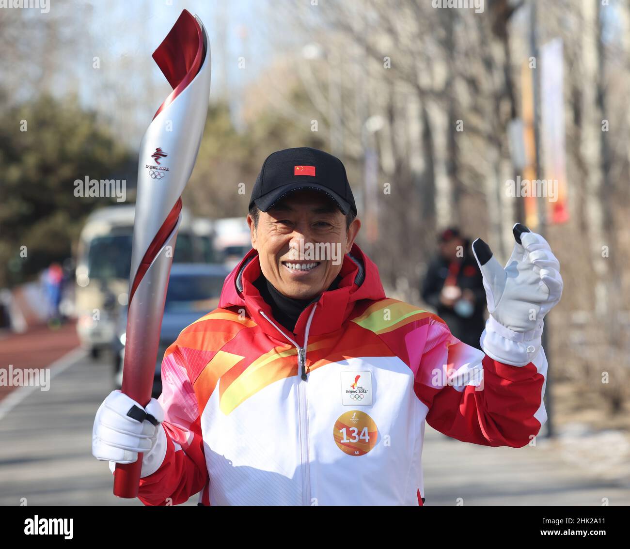Beijing, China. 2nd Feb, 2022. Torch bearer Zhang Yimou runs with the torch during the Beijing ...