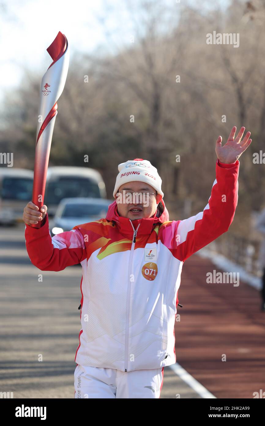 Beijing, China. 2nd Feb, 2022. Torch bearer Zhang Mingdong runs with ...