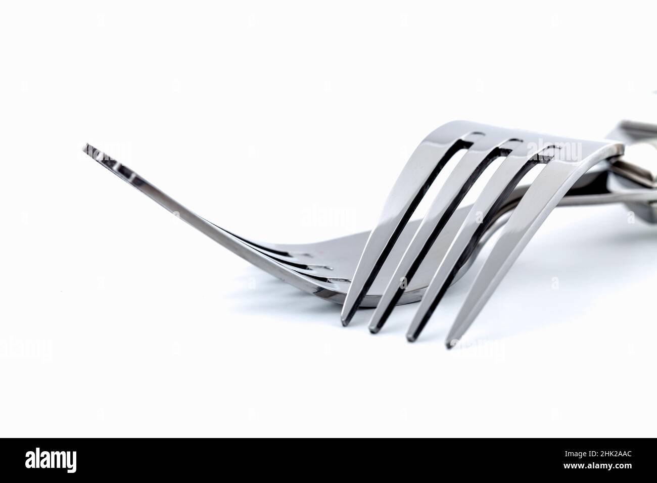 two metal silver forks on a white background Stock Photo - Alamy