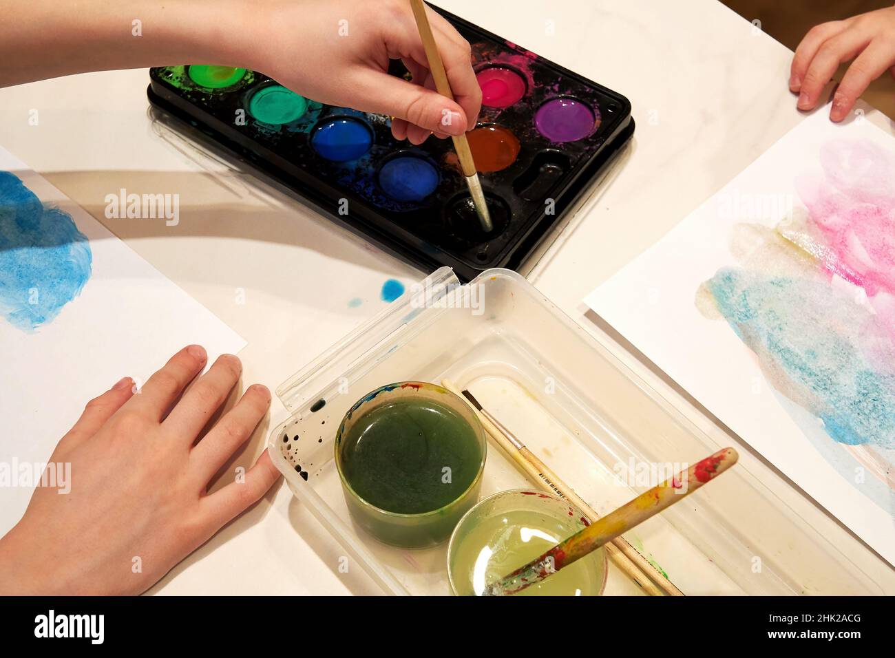 Two child brothers painting at home with watercolor paints. Hobby and ...