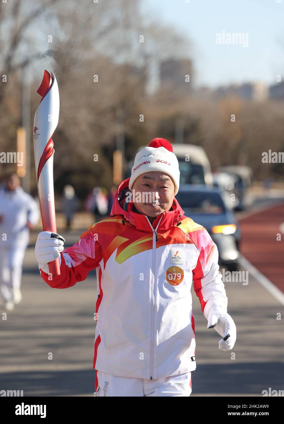 Beijing, China. 2nd Feb, 2022. Torch bearer Li Xinmin runs with the torch during the Beijing ...