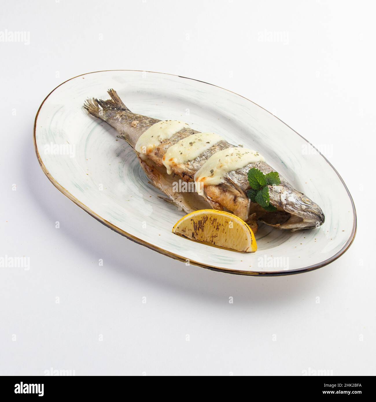 Gourmet fish dish isolated on a white background Stock Photo - Alamy
