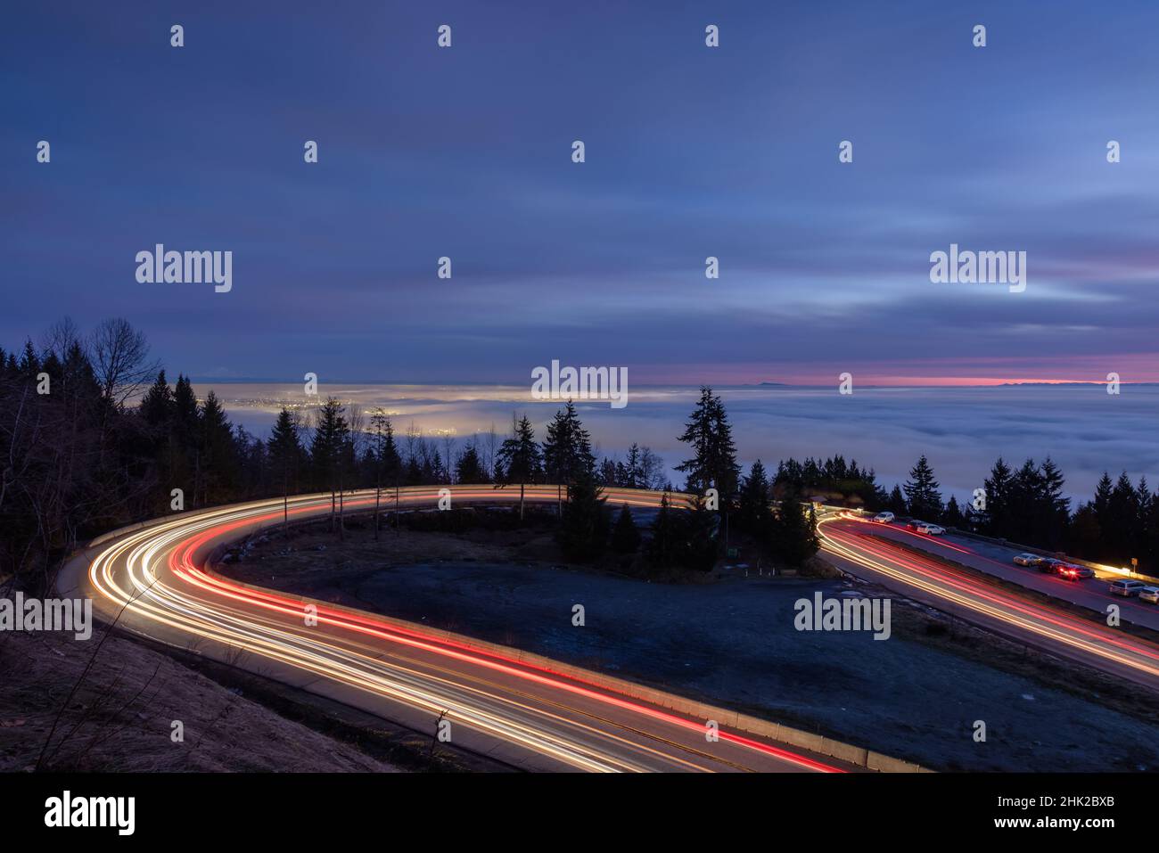 Road going up a mountain and Fog Covering the Modern City Stock Photo ...