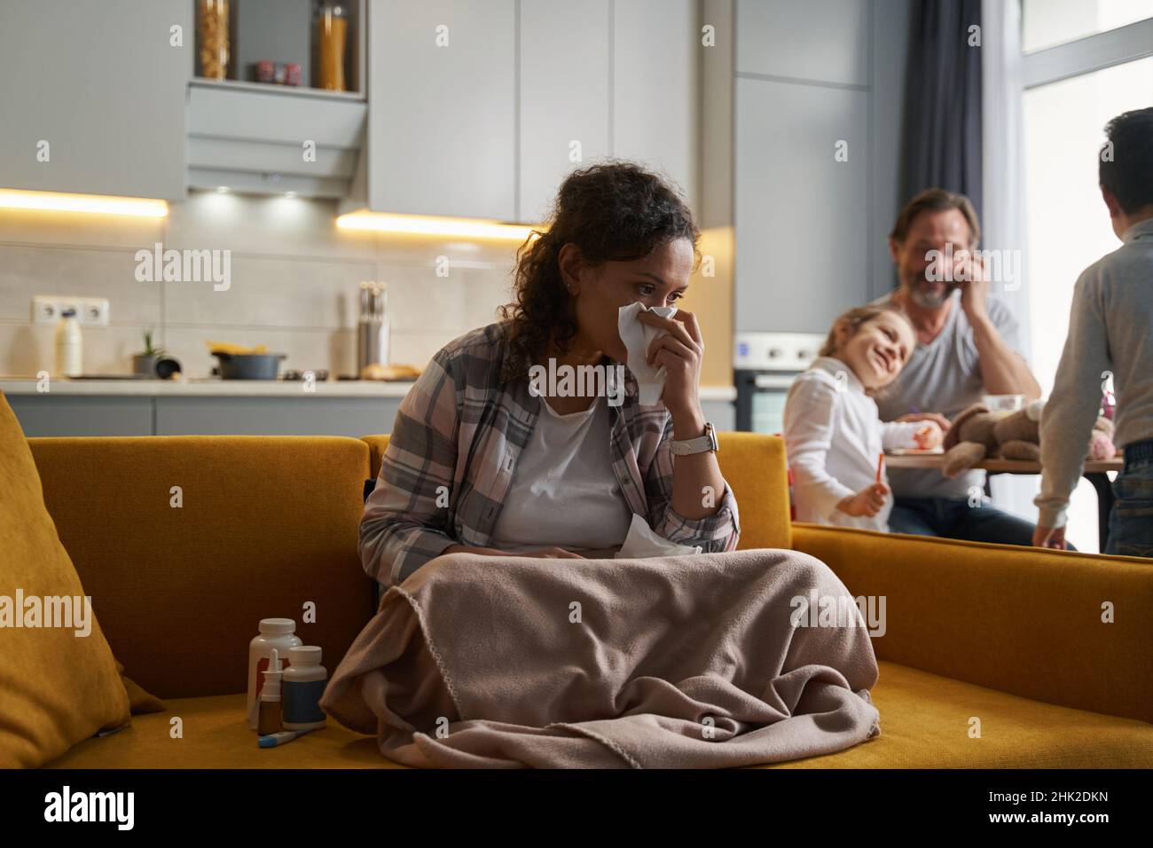 Sick lady at home blowing nose into tissue Stock Photo - Alamy