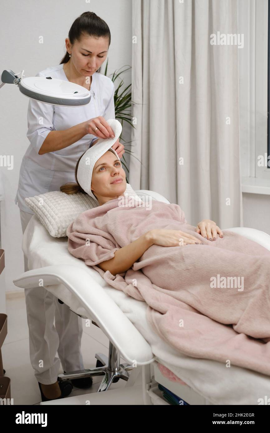 Happy woman at cosmetologist, before care and treatment procedure in ...