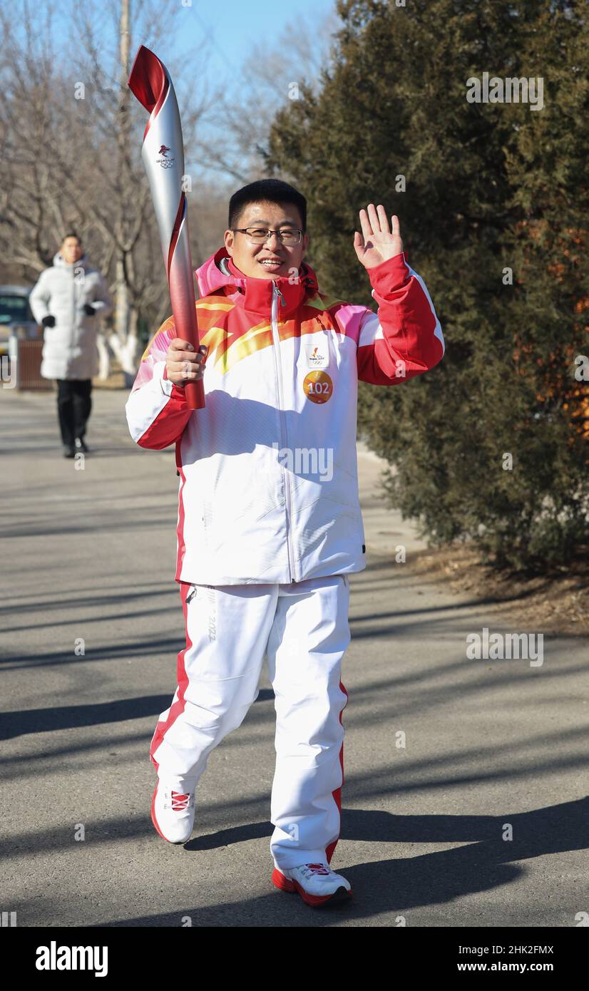 Beijing, China. 2nd Feb, 2022. Torch bearer Shi Gang runs with the torch during the Beijing 2022 ...