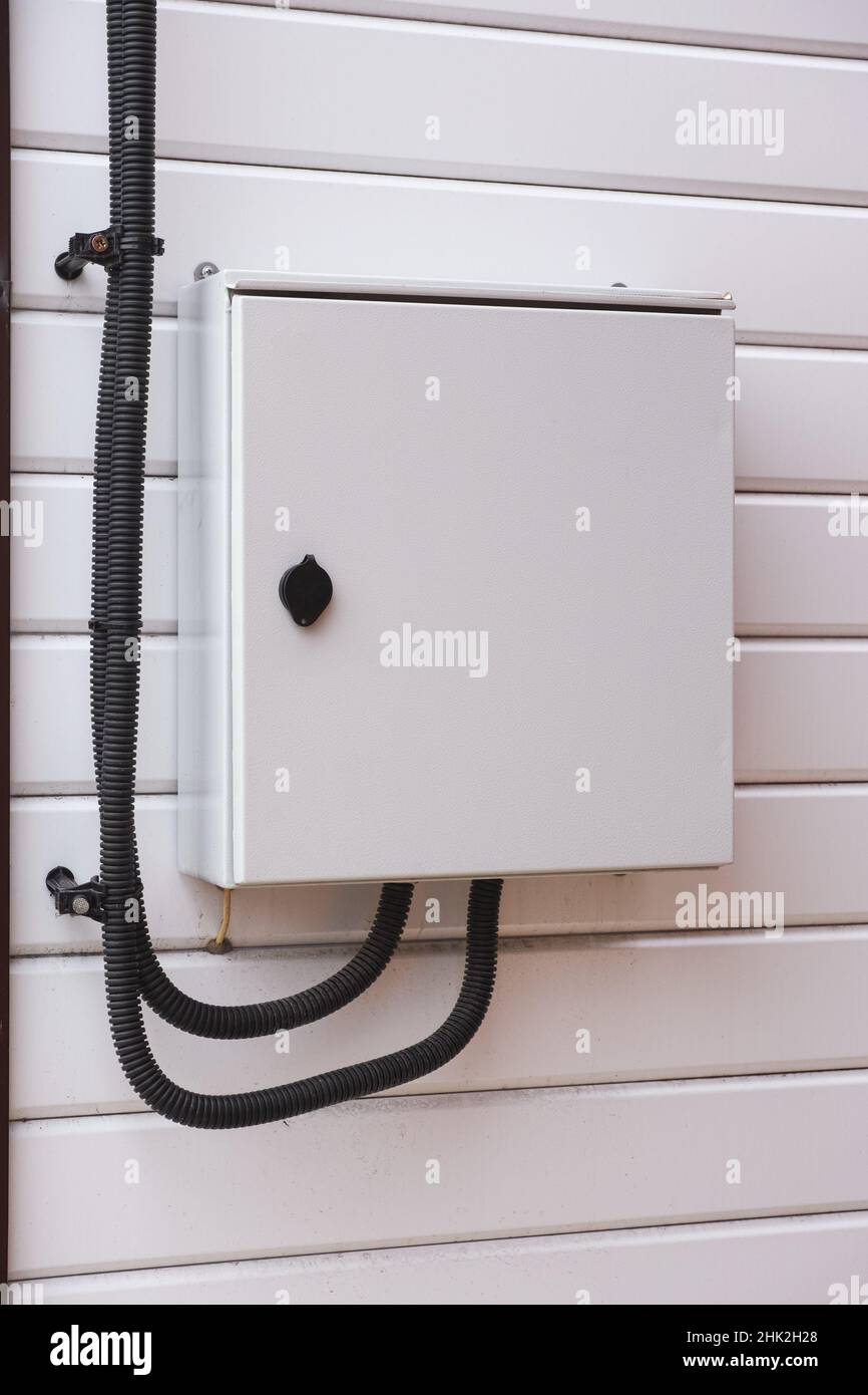 Gray Electrical panel with an electric wires in it on a wall outside ...