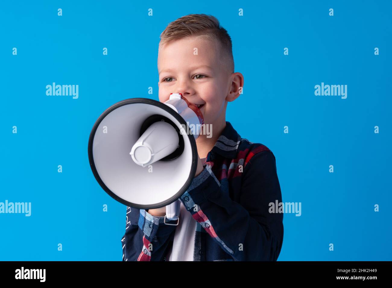 Cute little boy with megaphone on blue background Stock Photo - Alamy