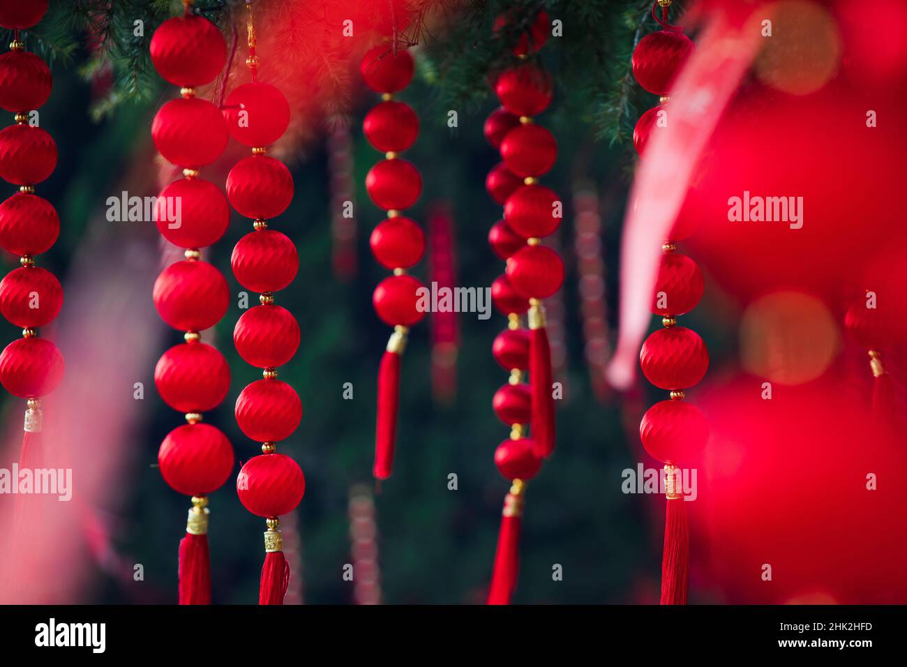 Red decorations hanging from tree branches in Chinese garden Stock ...