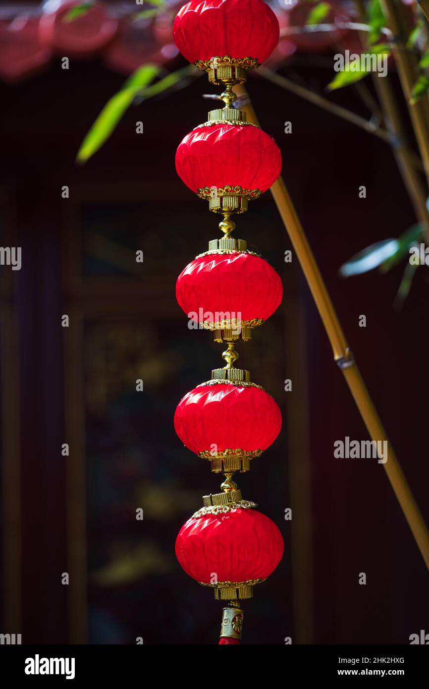 Red decorations hanging from tree branches in Chinese garden Stock ...