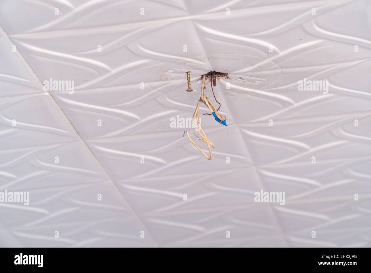 Dangerous bad wiring which hangs on the ceiling Stock Photo - Alamy