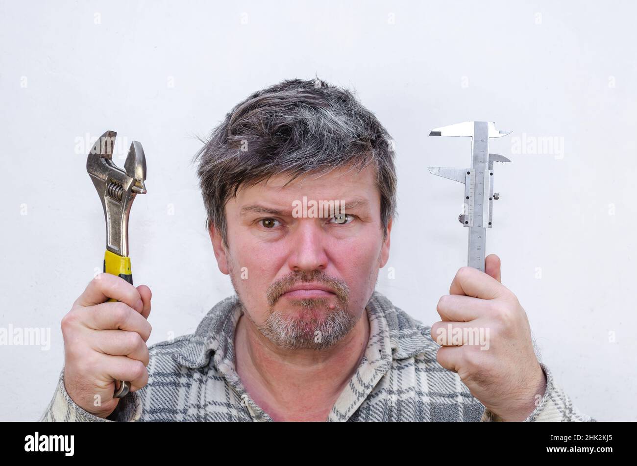 An adult Man with a seriously pompous grimace is holding a caliper and ...