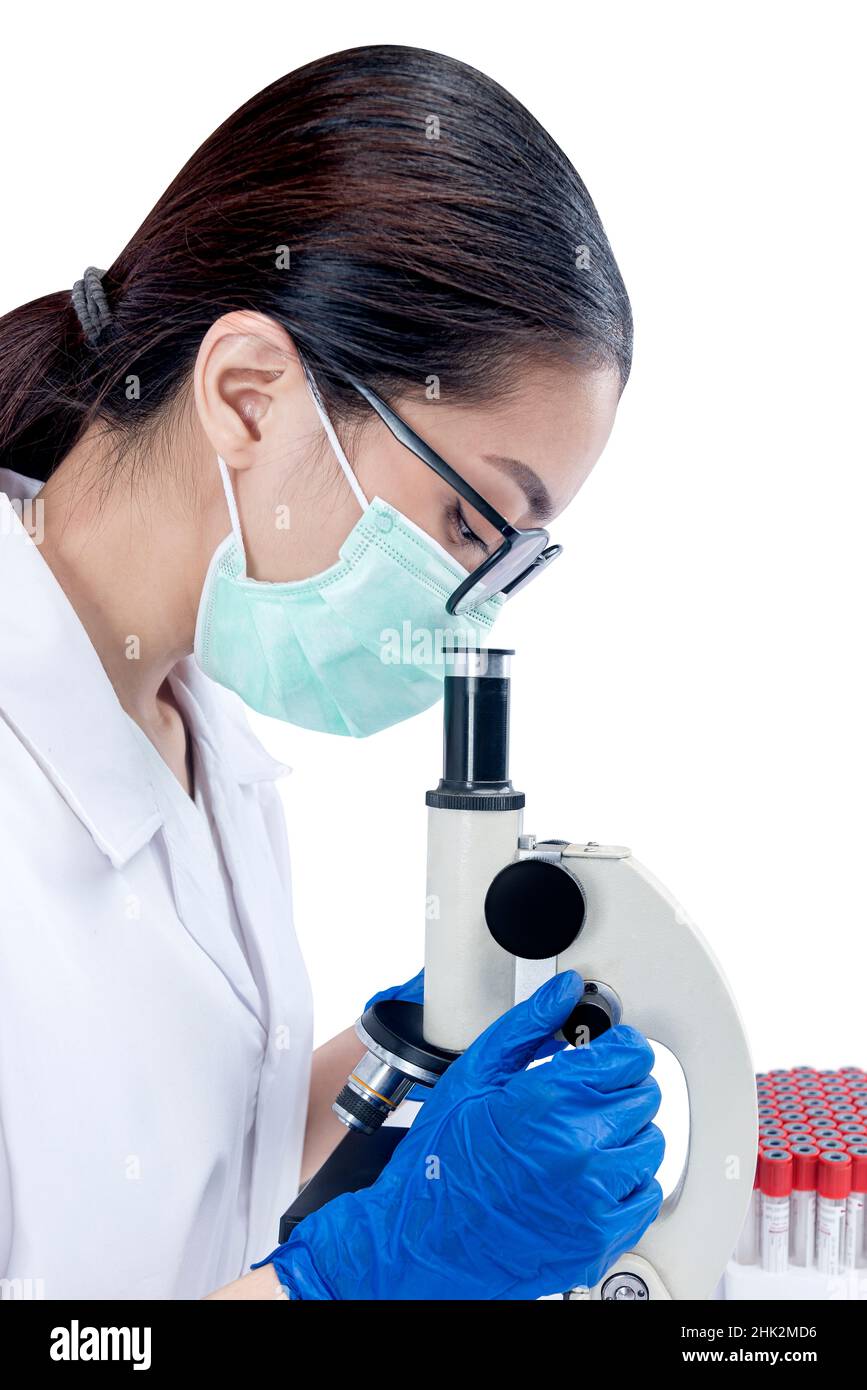 Asian researcher woman with face mask and glasses using microscope ...