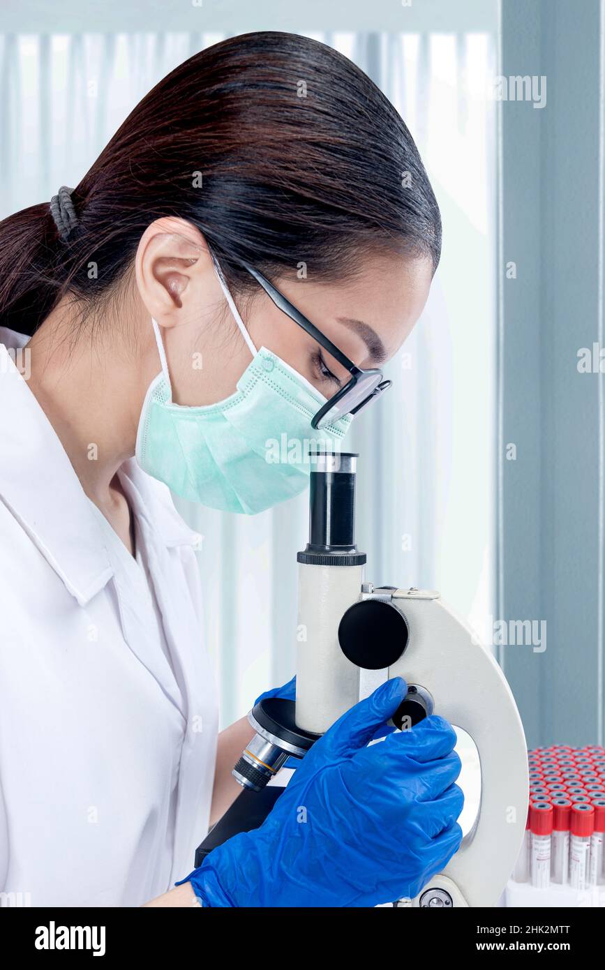 Asian lab technician on microscope hi-res stock photography and images ...
